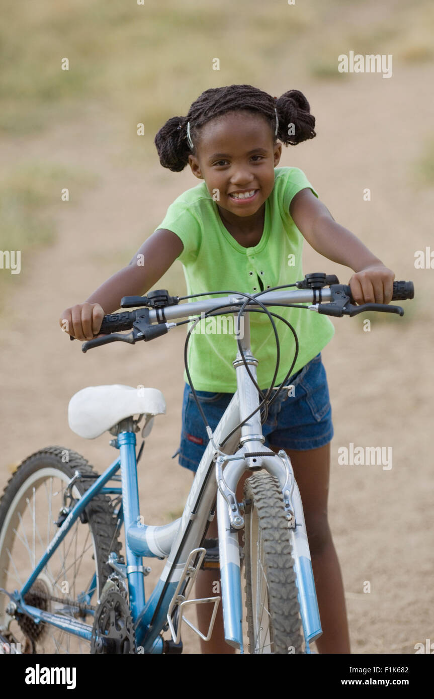 Girl pushing bicycle Stock Photo - Alamy