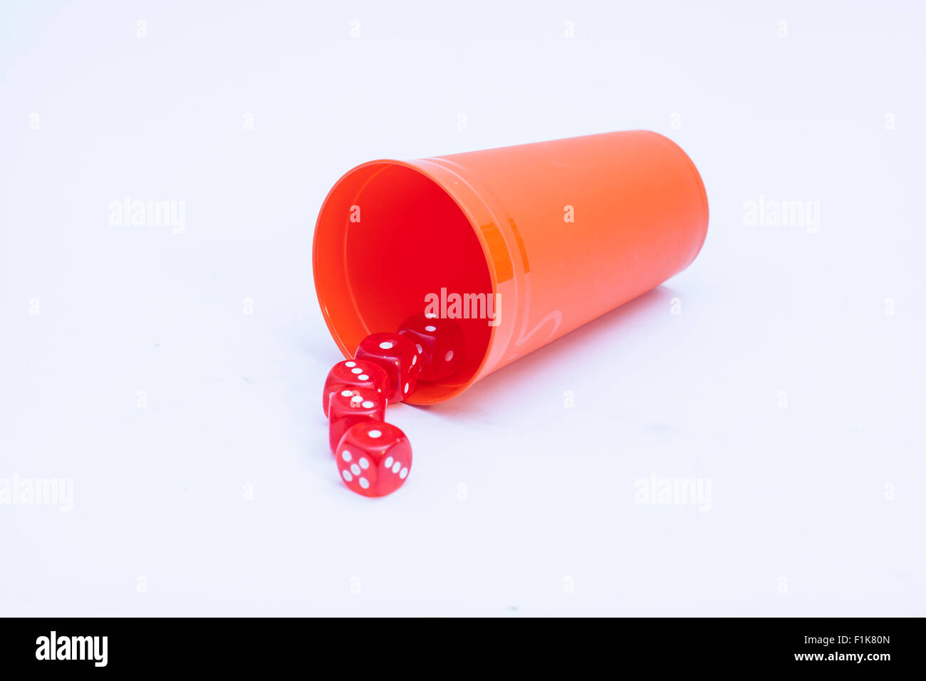 Red dice cup with five red winning dice Stock Photo - Alamy