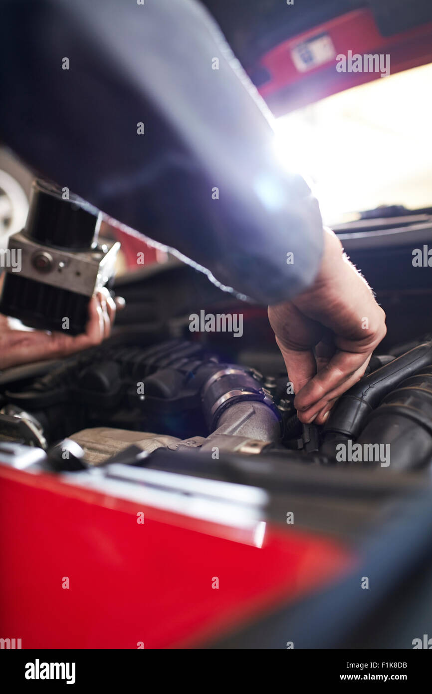 Close up mechanic arm reaching in car engine Stock Photo - Alamy