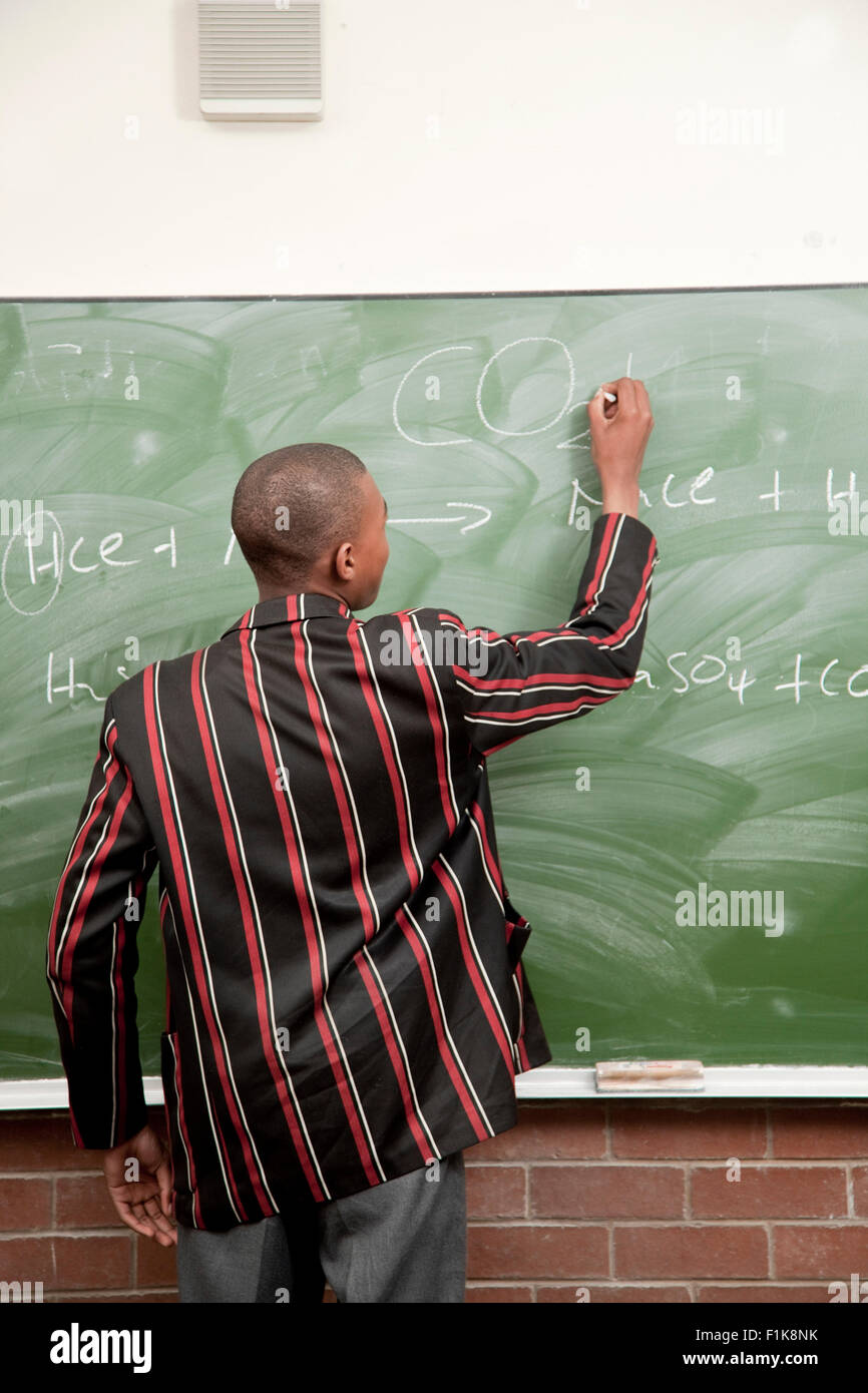 A male high school student writing on a chalkboard Stock Photo - Alamy