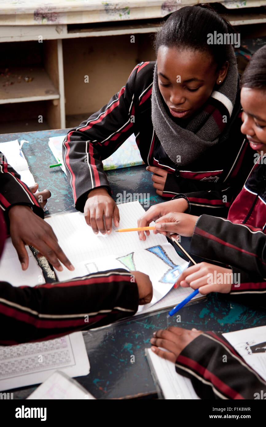 A group of high school girls sit around a table studying Stock Photo ...