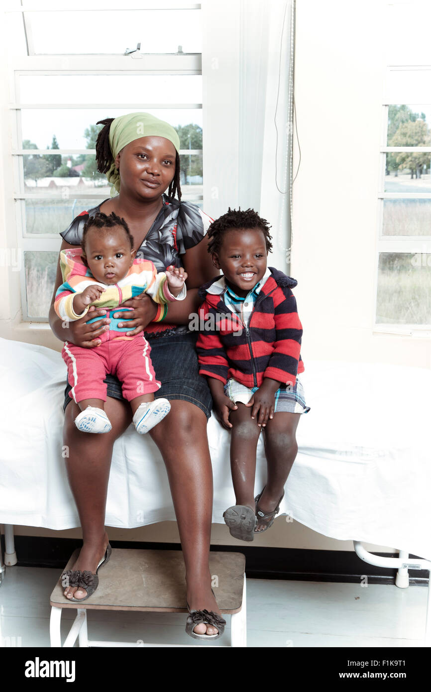 Mother and her two children wait for the doctor in the clinic ward ...