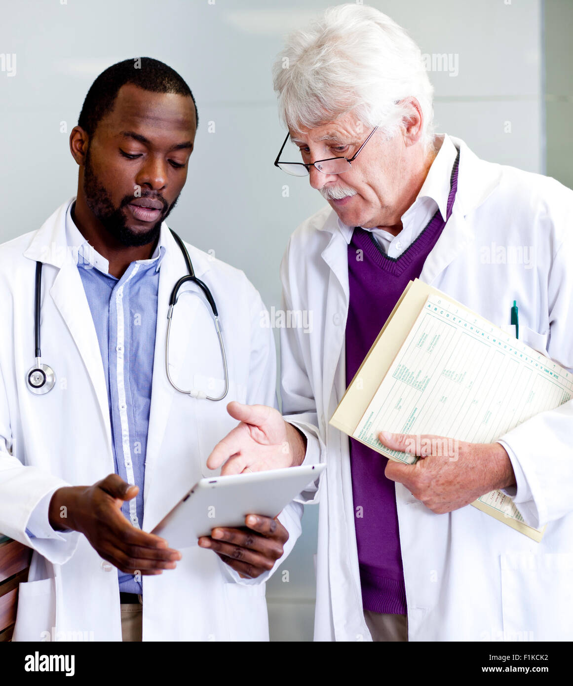 Two doctors going over reports on a tablet Stock Photo - Alamy