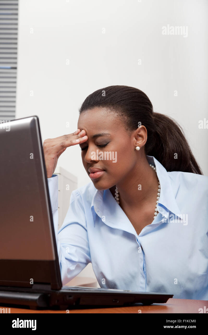 A black business woman puzzles over her laptop screen Stock Photo - Alamy