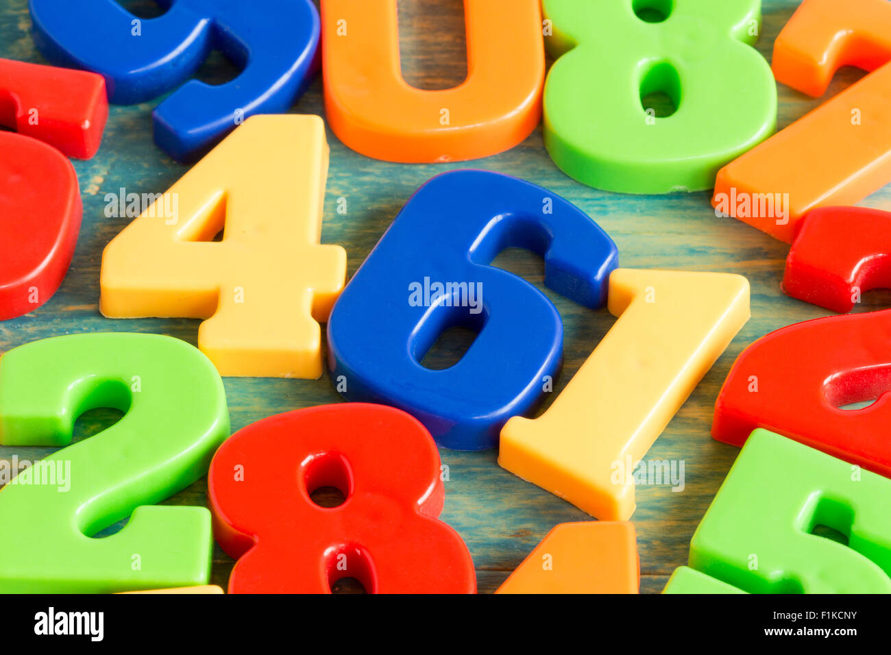Colorful plastic numbers on a painted wooden background Stock Photo - Alamy