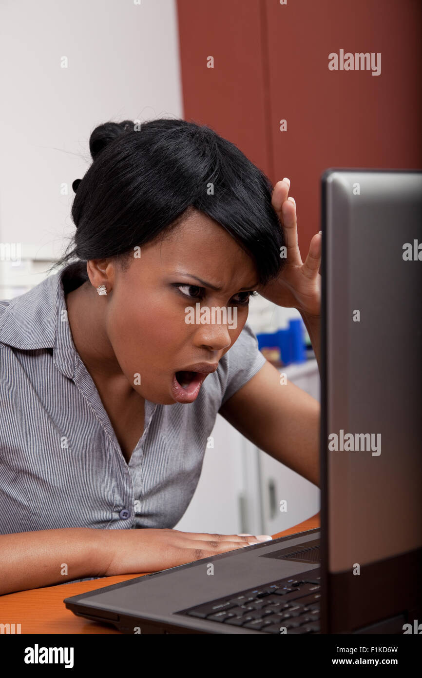 A black business woman puzzles over her laptop screen Stock Photo - Alamy