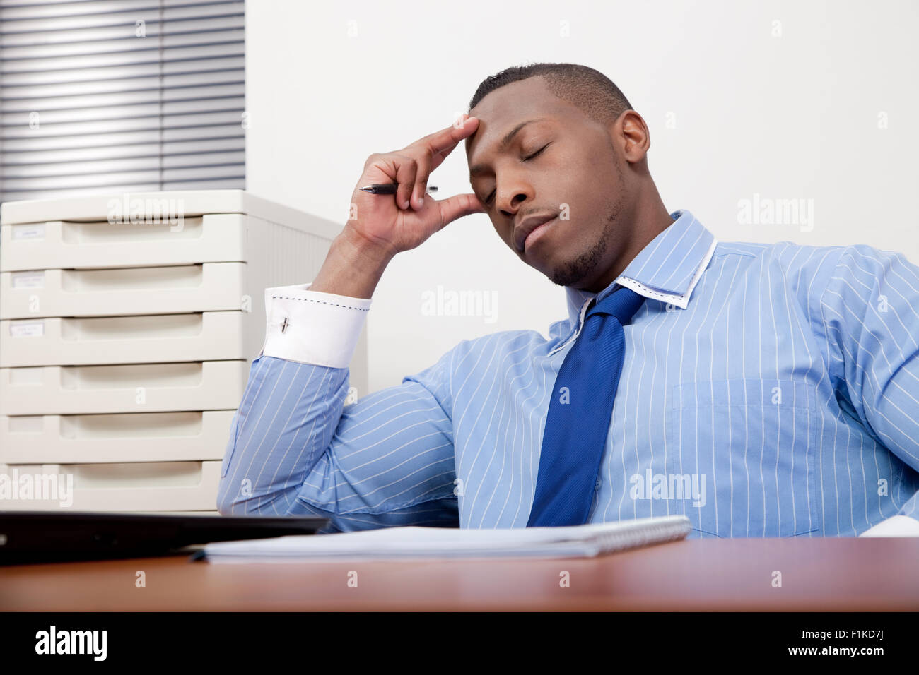 A black businessman dozed off at his desk Stock Photo - Alamy