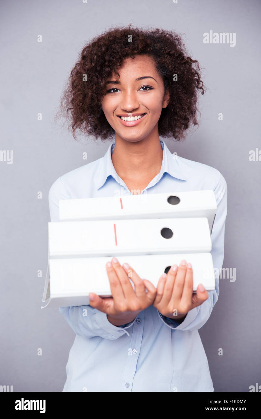 Portrait of a cheerful afro american businesswoman holding folders on ... Portrait of a cheerful afro american businesswoman holding folders on ...