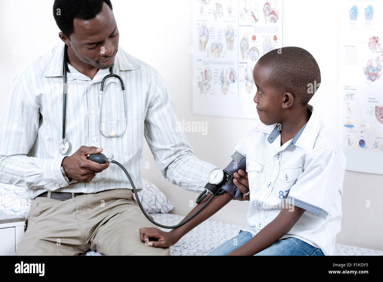 Doctor checking African child's blood pressure in a doctor's room Stock ...