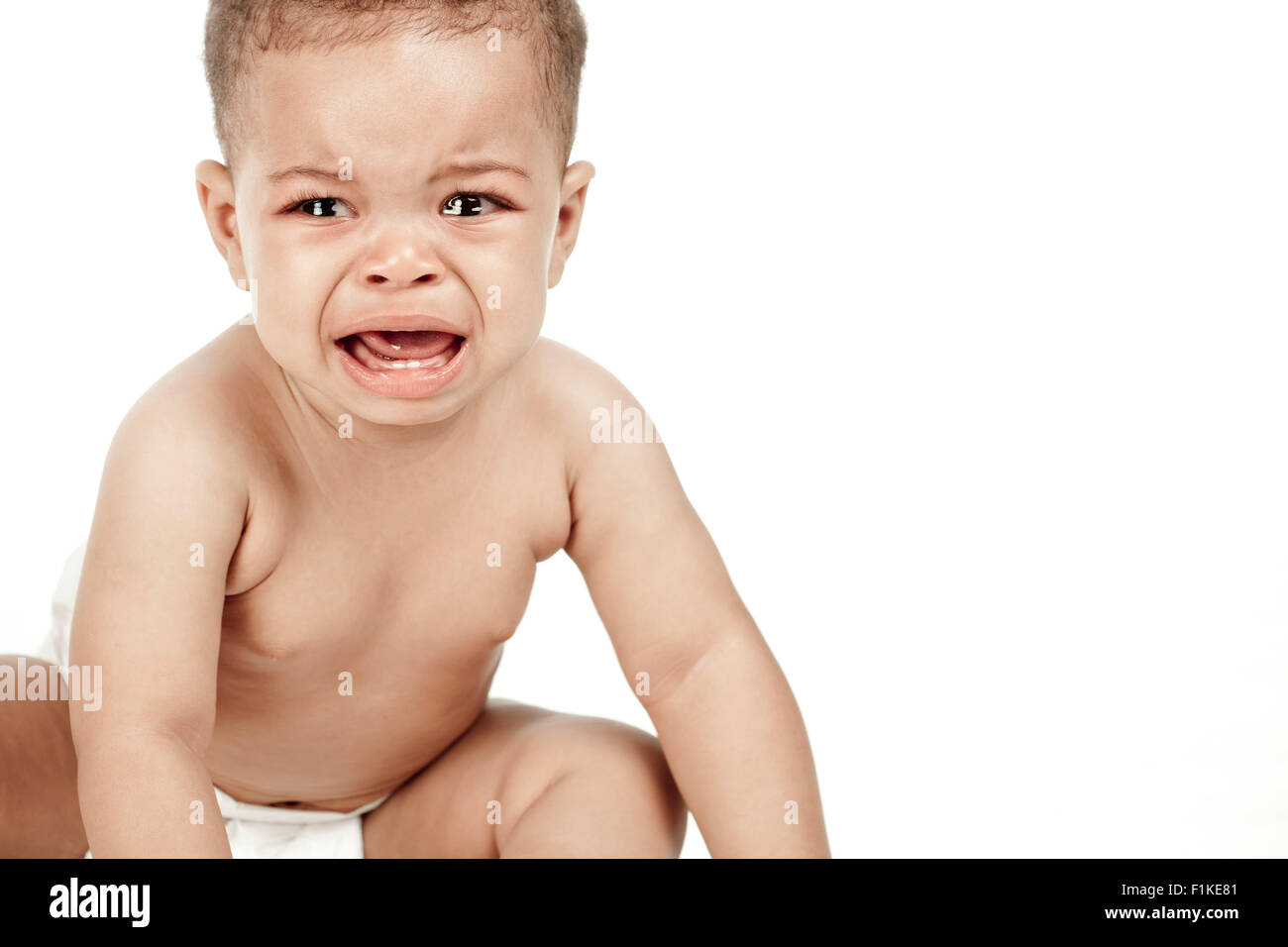 An infant sitting in front of a white background, crying Stock Photo ...