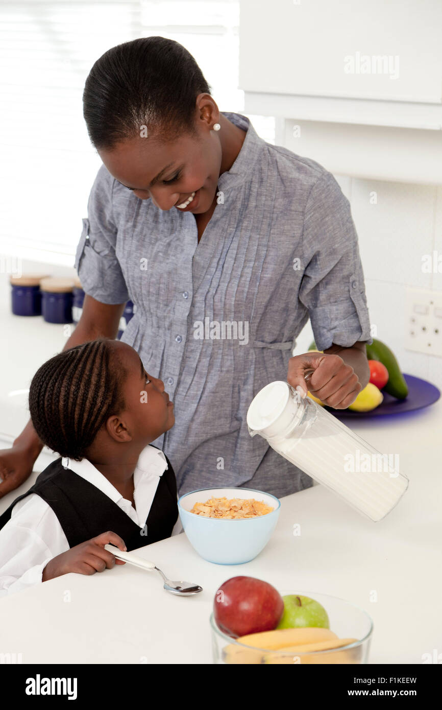 Young African mother serving food in the kitchen with her son Stock ...