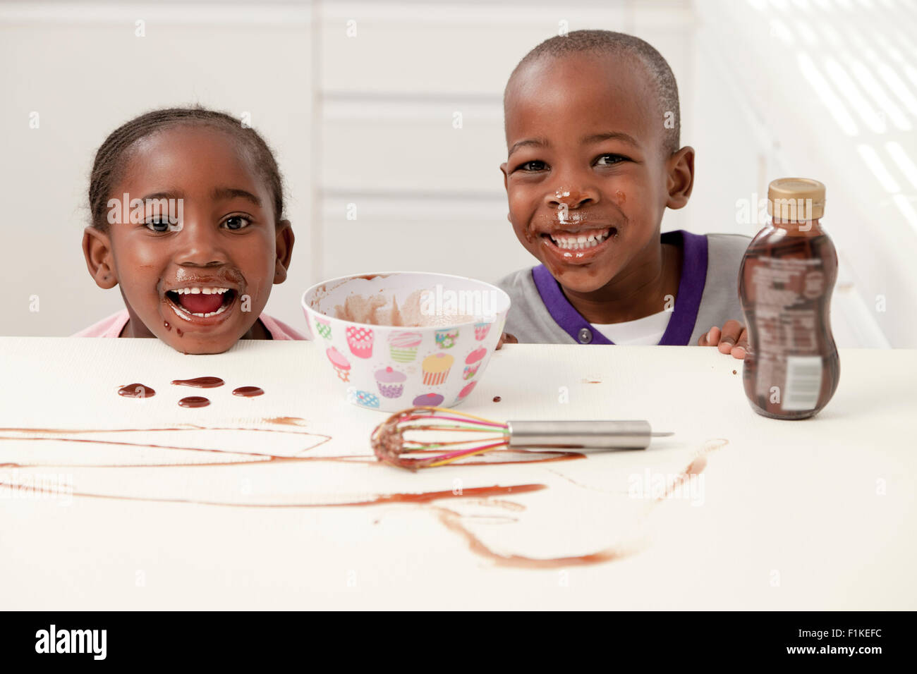 Two you African siblings eat together in the kitchen Stock Photo - Alamy