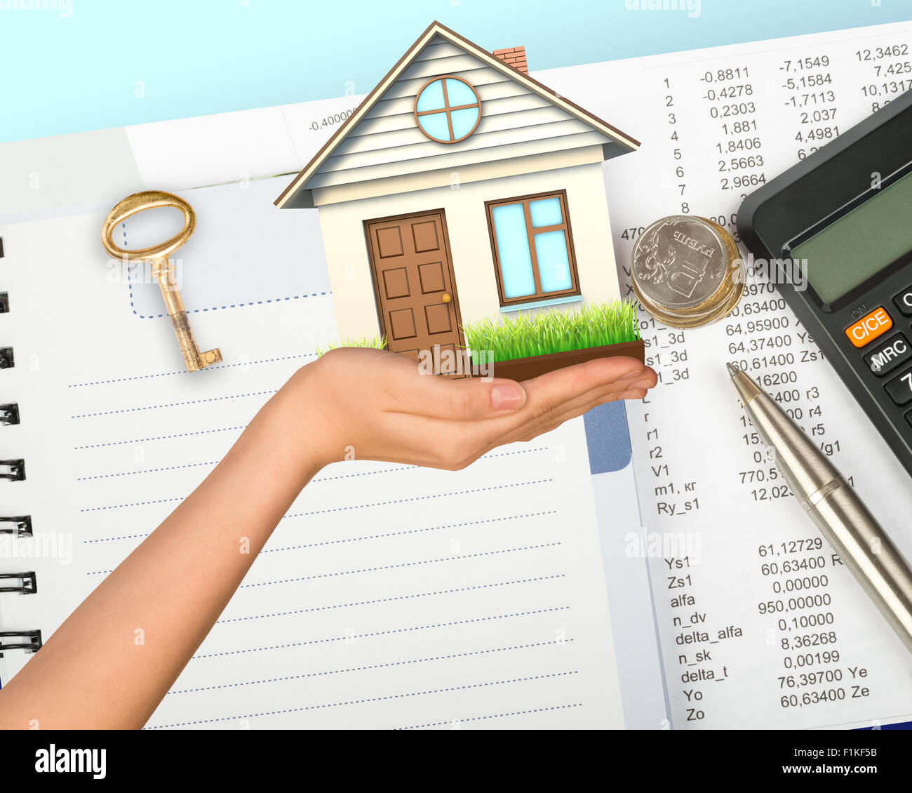 Humans hand holding house with key and calculator Stock Photo - Alamy