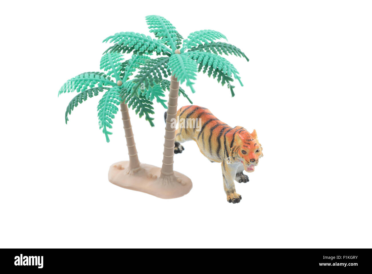 A small toy tiger with trees isolated on a white background Stock Photo ...