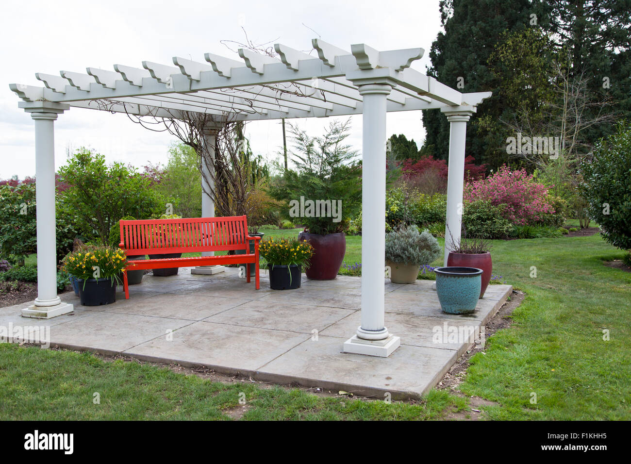 A large white wooden gazebo structure on a concrete platform and a red ...