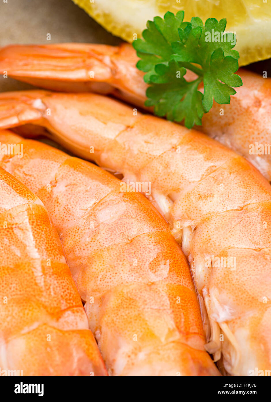 Vertical image of king tiger prawns prepared in a tray with lemon and ...