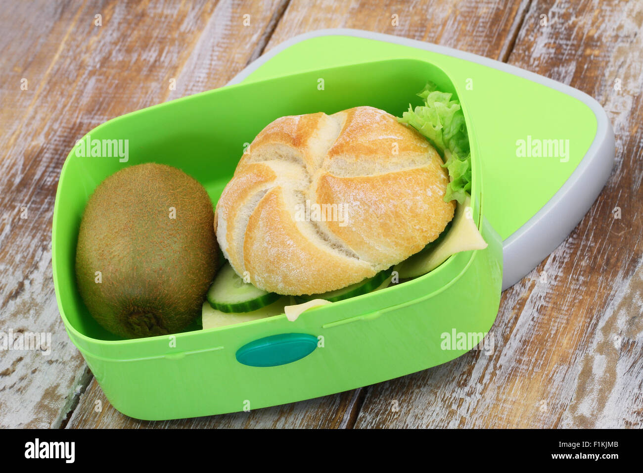 Lunch box with cheese bread roll and kiwi fruit Stock Photo - Alamy