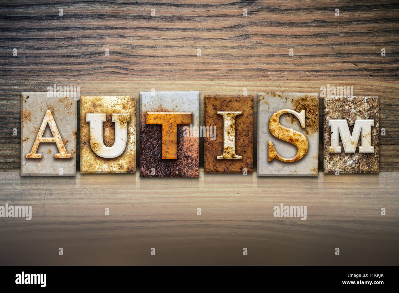 The word "AUTISM" written in rusty metal letterpress type sitting on a ...