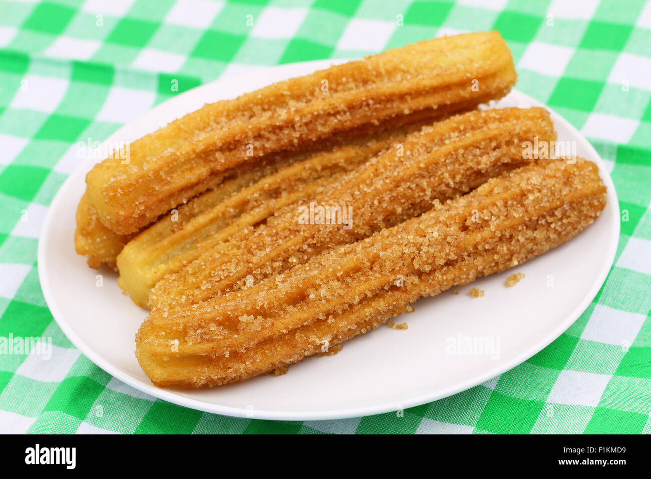 Spanish churros on plate on checkered cloth Stock Photo - Alamy