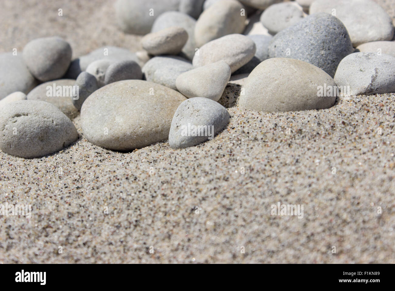 grey Pebbles in the sand Stock Photo - Alamy