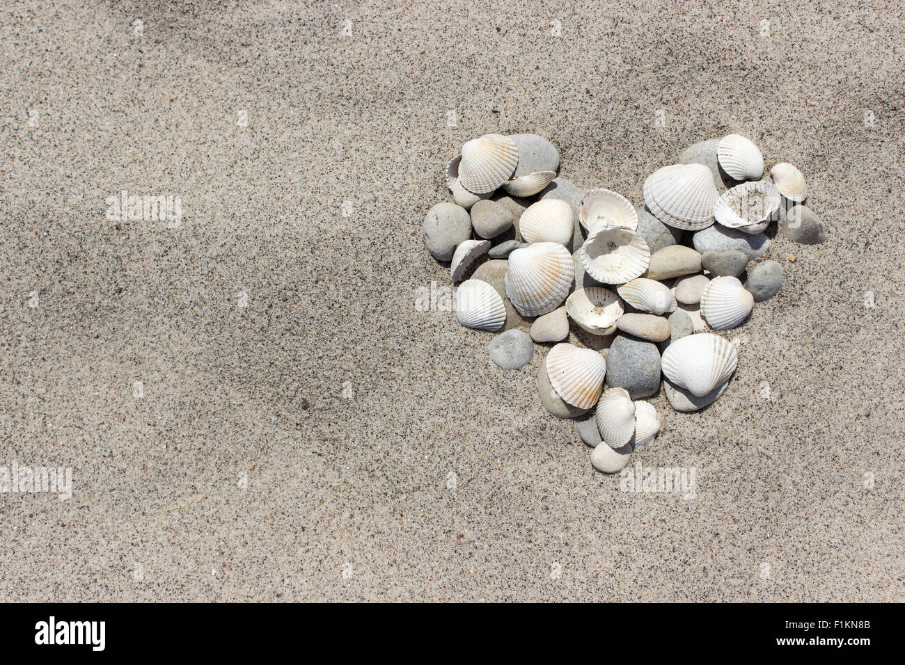 Heart made of shells and pebbles in the sand Stock Photo - Alamy