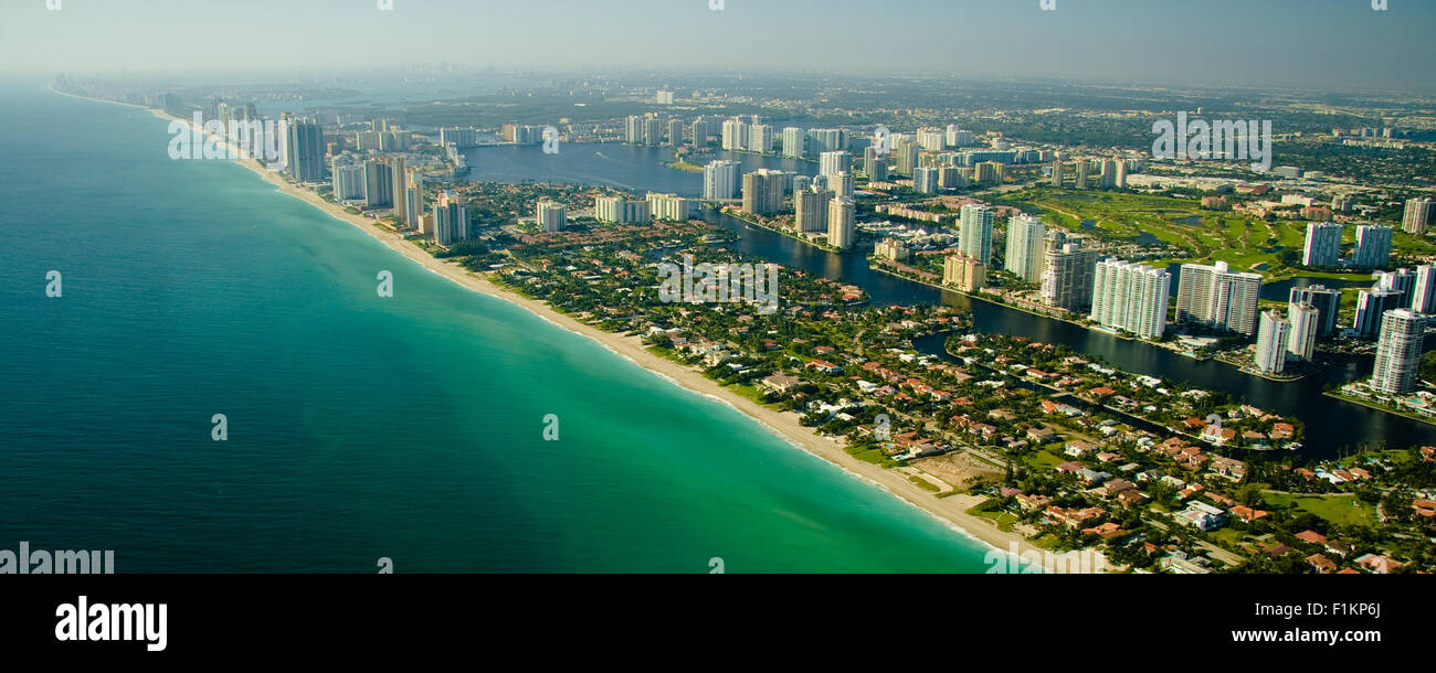 An aerial view of Miami’s seashore with deep green and blue water in ...