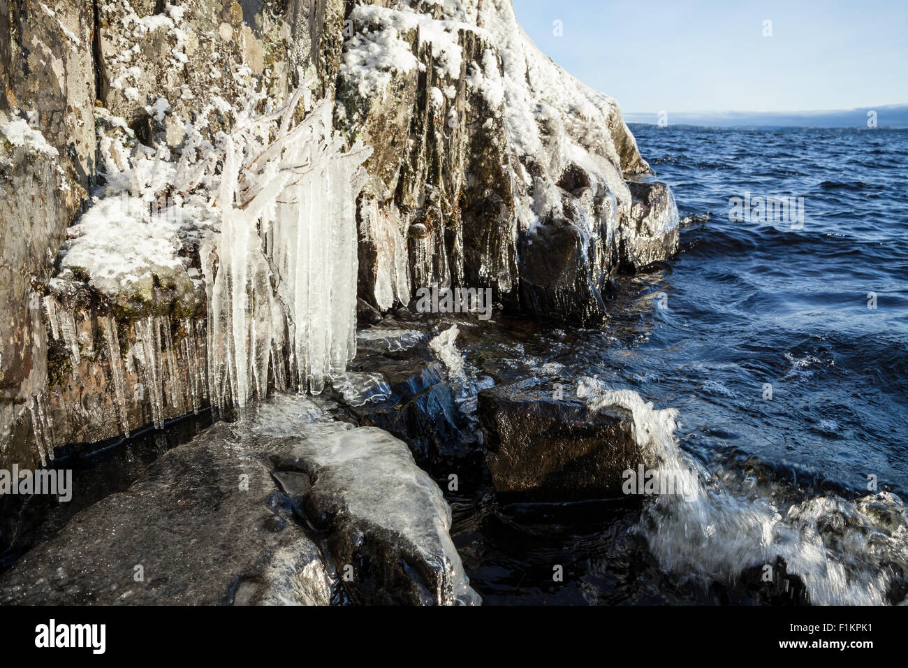 Frozen lakefront rock cliff Stock Photo - Alamy