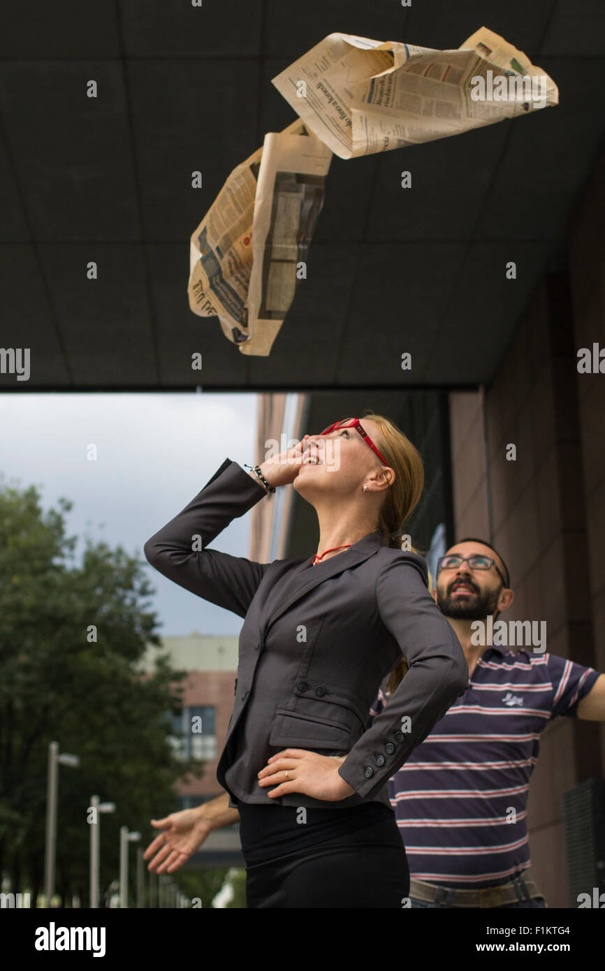 Young blonde business woman with a flying newspaper above her head in ...