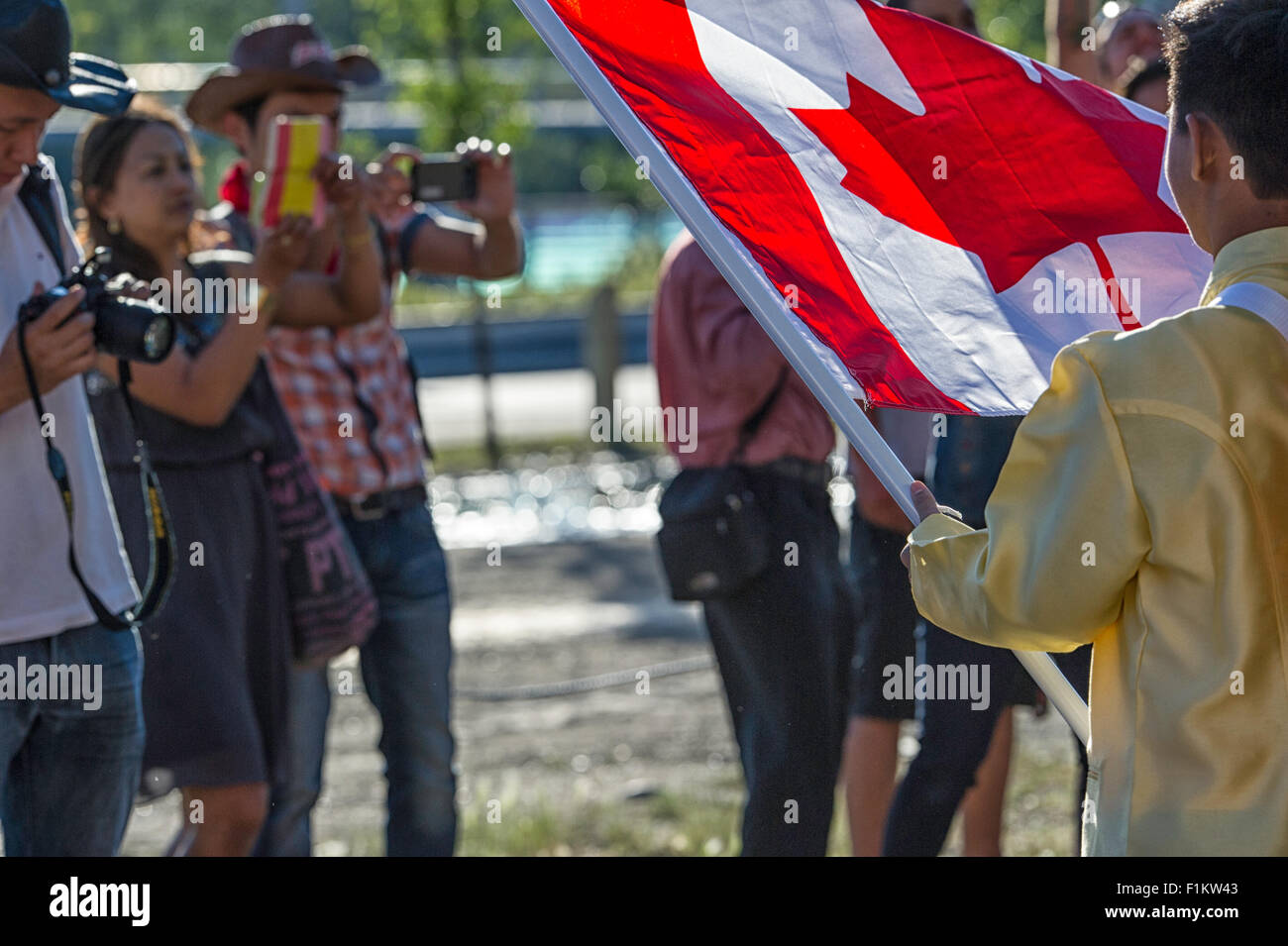 People taking photos of the Canadian flag at the Calgary Stampede ...