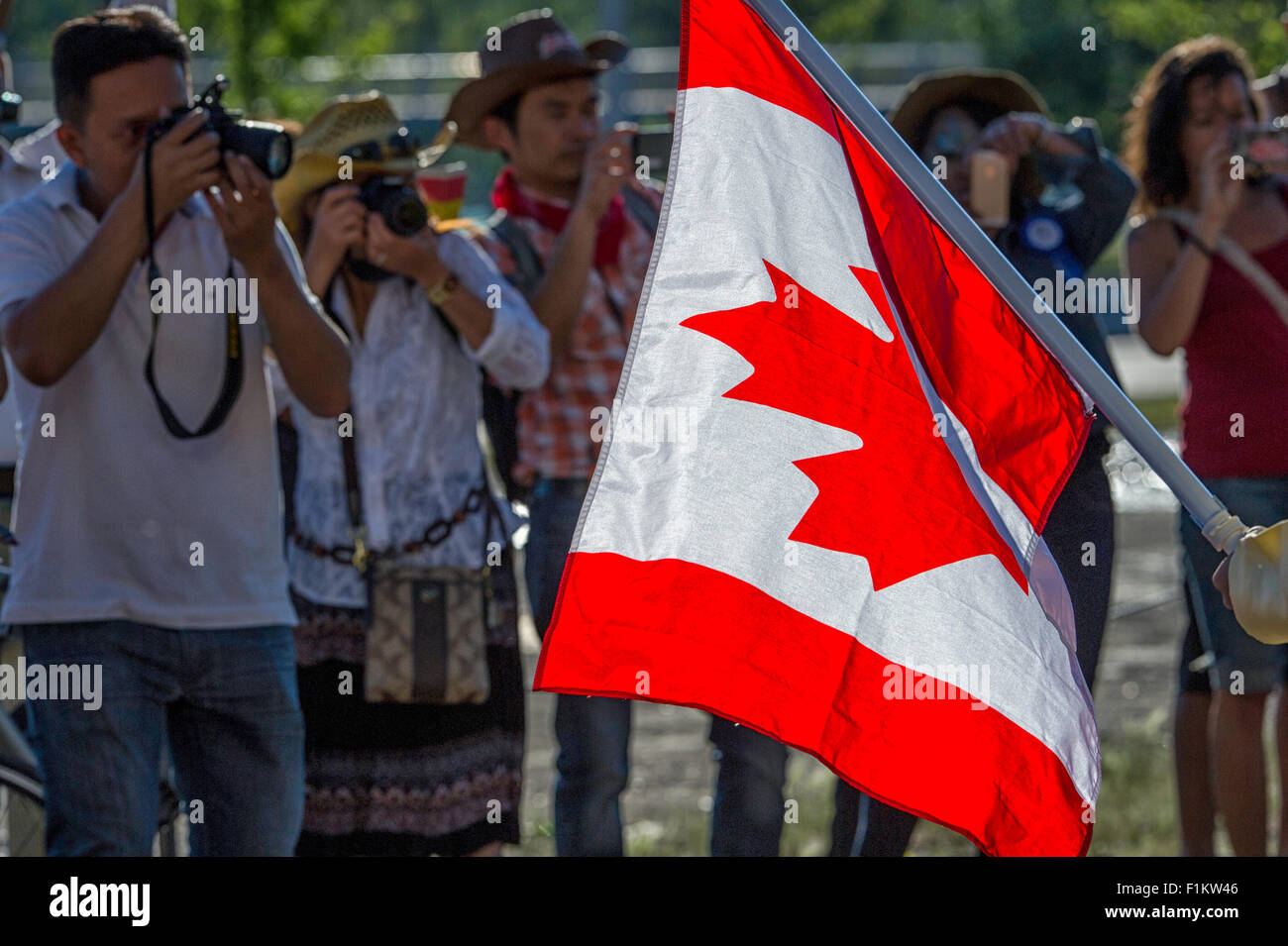 People taking photos of the Canadian flag at the Calgary Stampede ...
