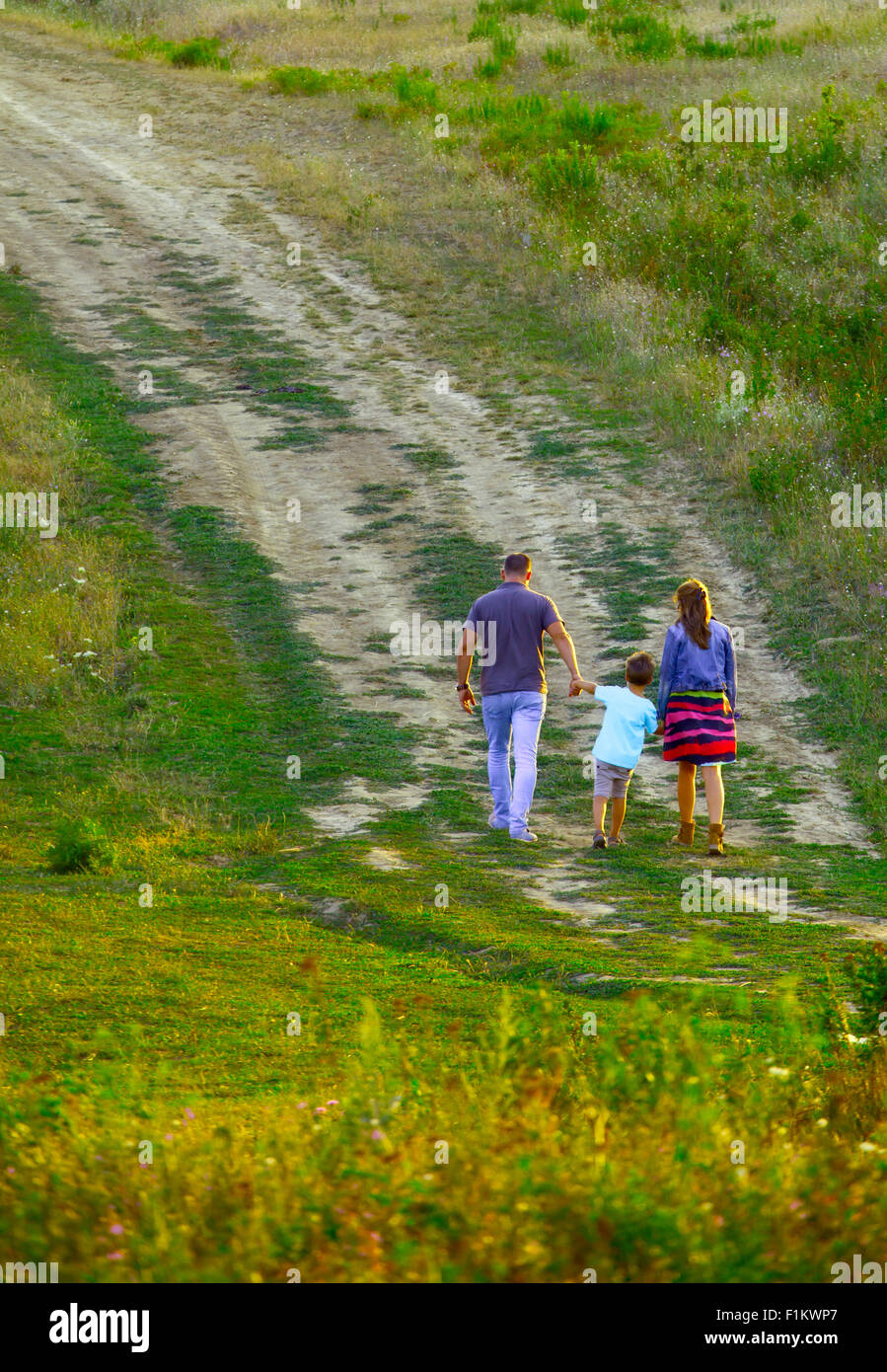 Mother and father walking on a countryside road with their son Stock ...
