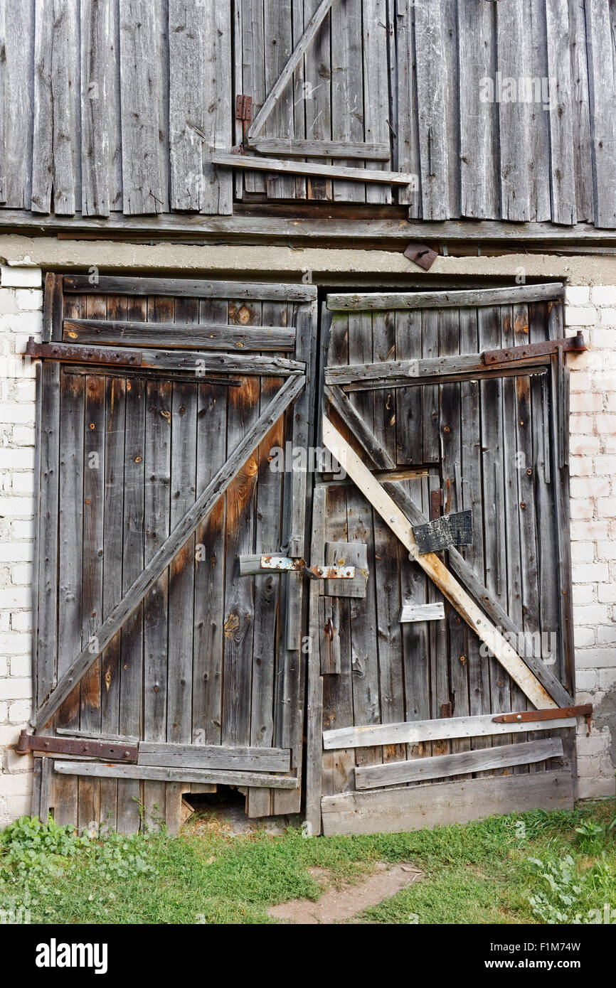 Rotten wooden gates in a brick wall of the destroyed rural shed Stock ...