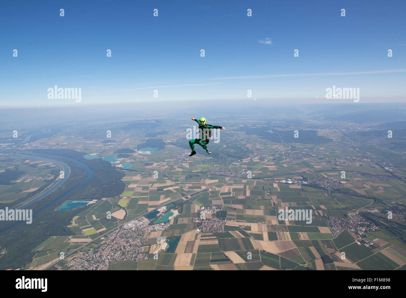 Freefly skydiver is practice the sit position and flying free over nice ...