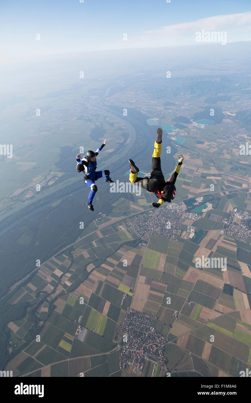 Skydiver are flying head up within a team in the sit fly position over ...