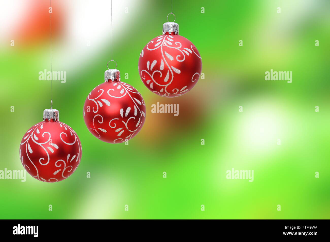 three christmas baubles hanging from the tree with space for text ...