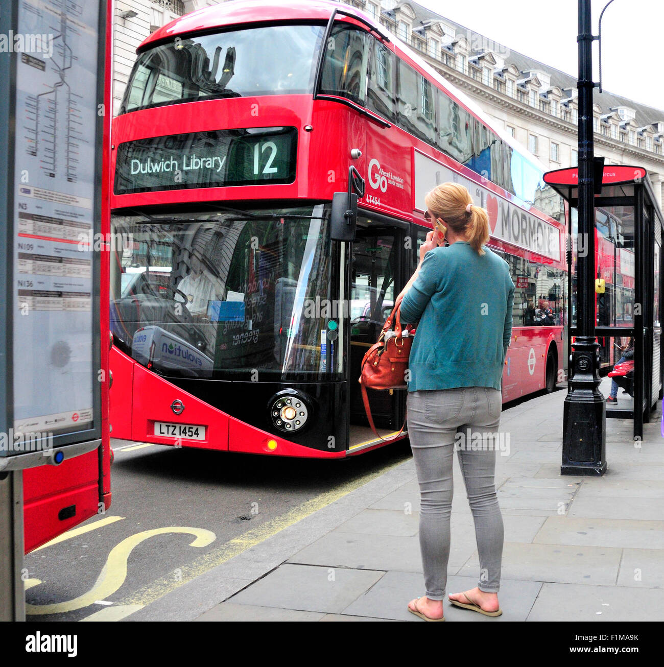 London, England, UK. Woman using a mobile phone by a bus stop Stock ...