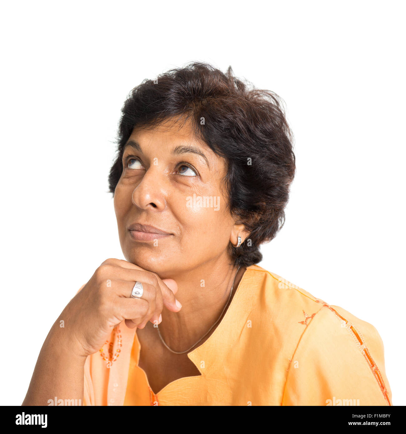 Portrait of a 50s Indian mature woman smiling and looking up having a ...