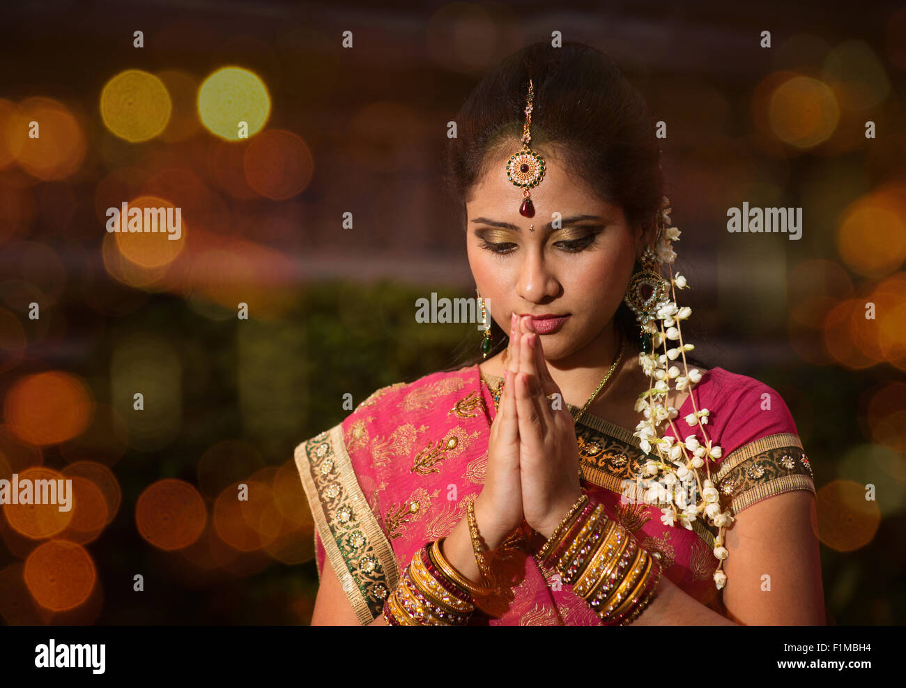 Indian female in traditional sari praying and celebrating Diwali or ...