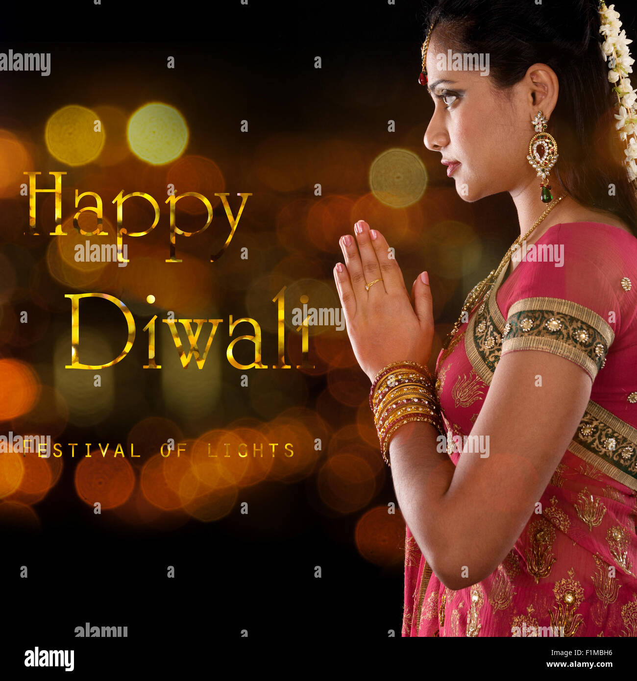 Indian woman in traditional sari praying and celebrating Diwali or ...