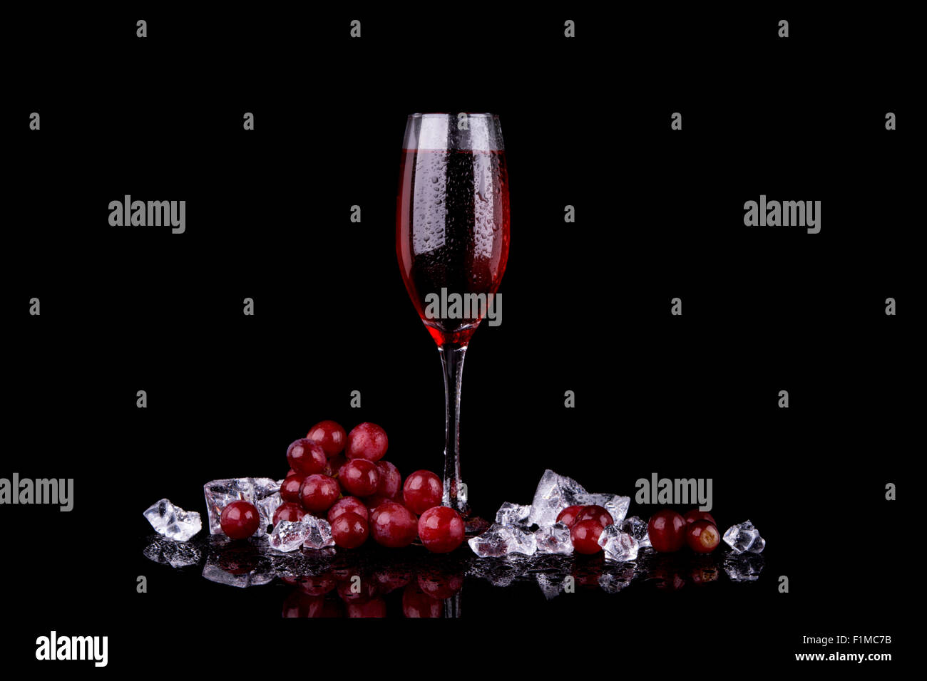 Red grape with glass of champagne on black background Stock Photo - Alamy