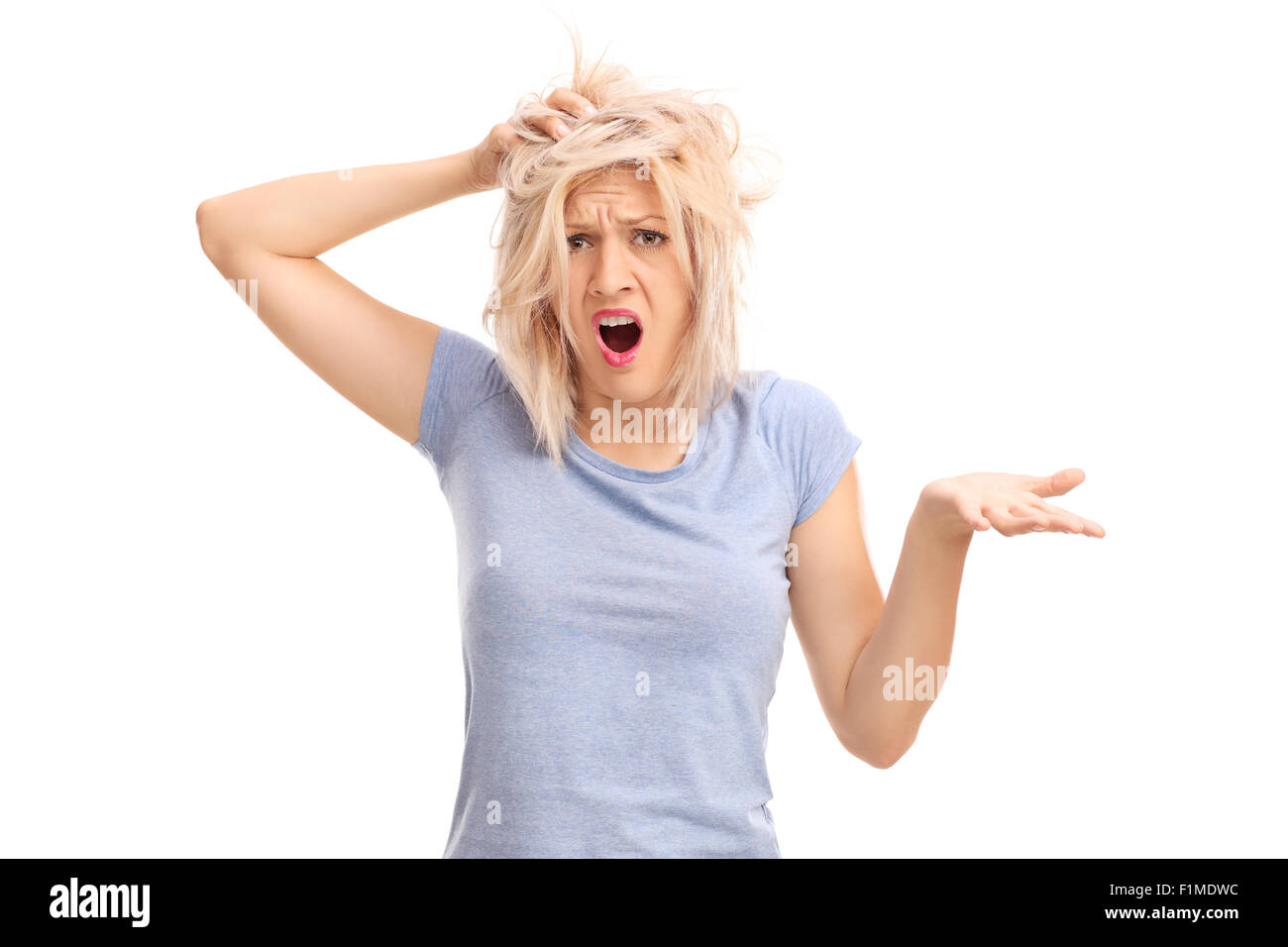 Confused girl with messy hair gesturing with her hand and looking at ...