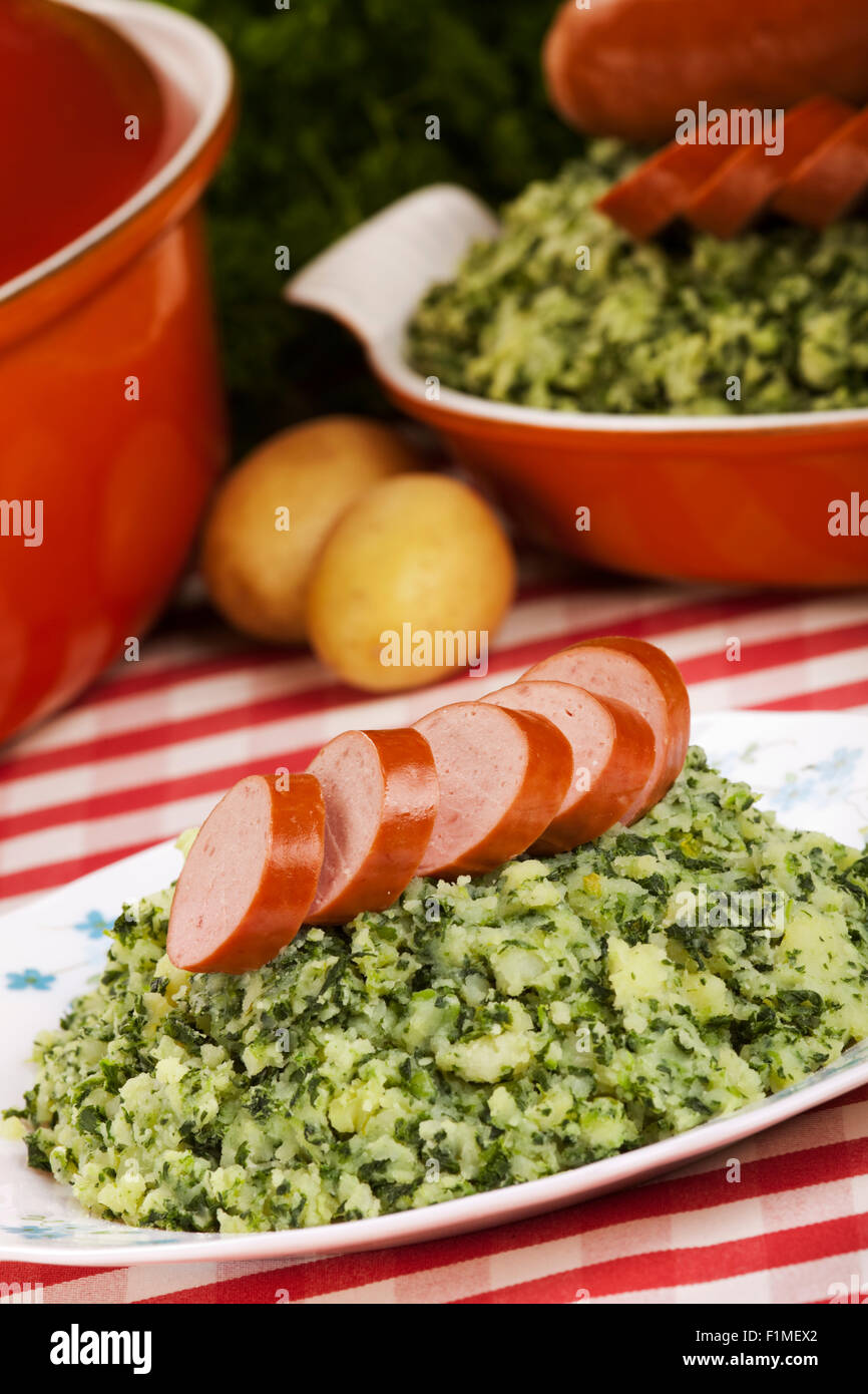 A rustic table with a plate with 'Boerenkool met worst' or kale with ...