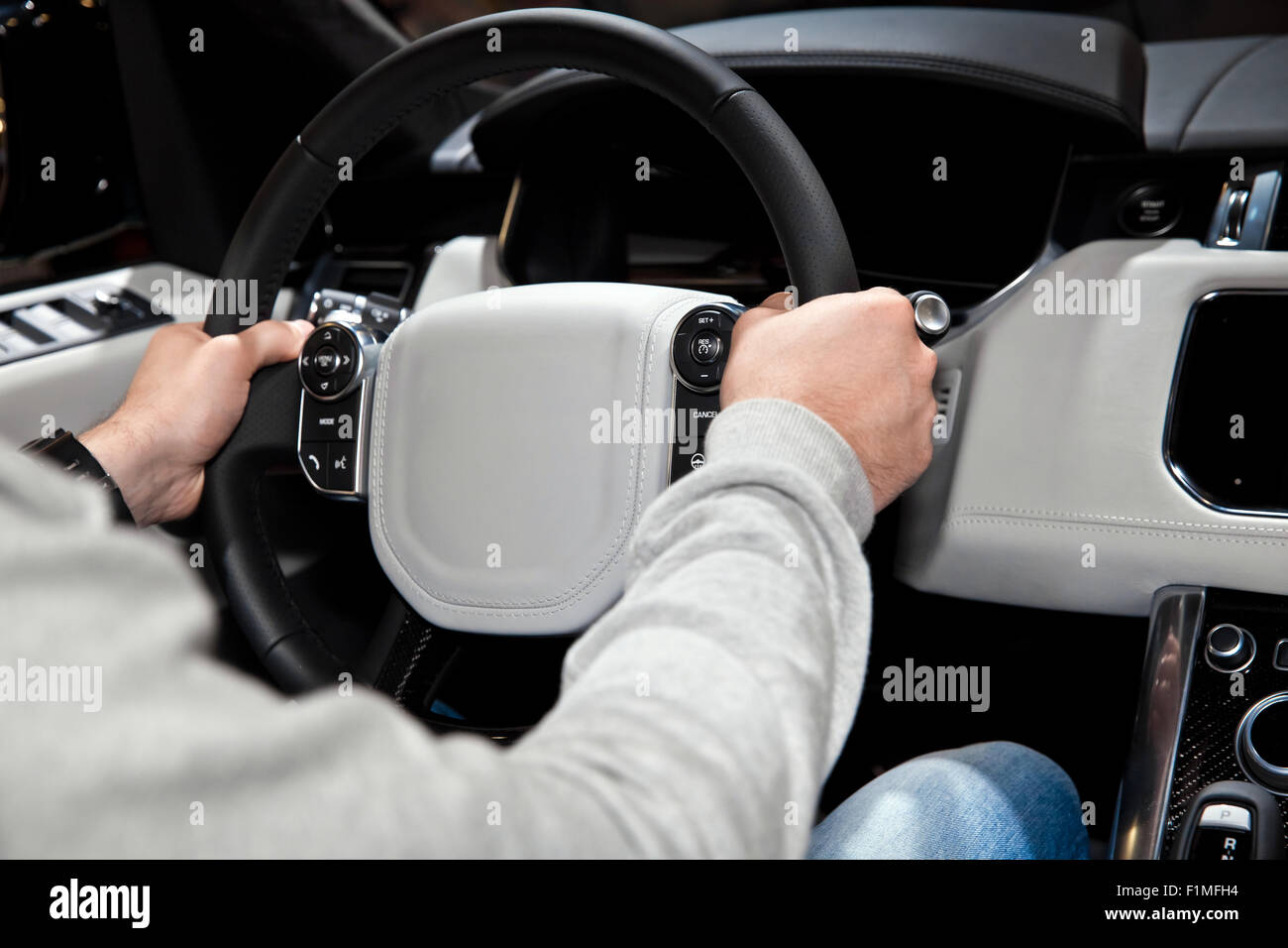 Hands on steering wheel in car interior Stock Photo - Alamy