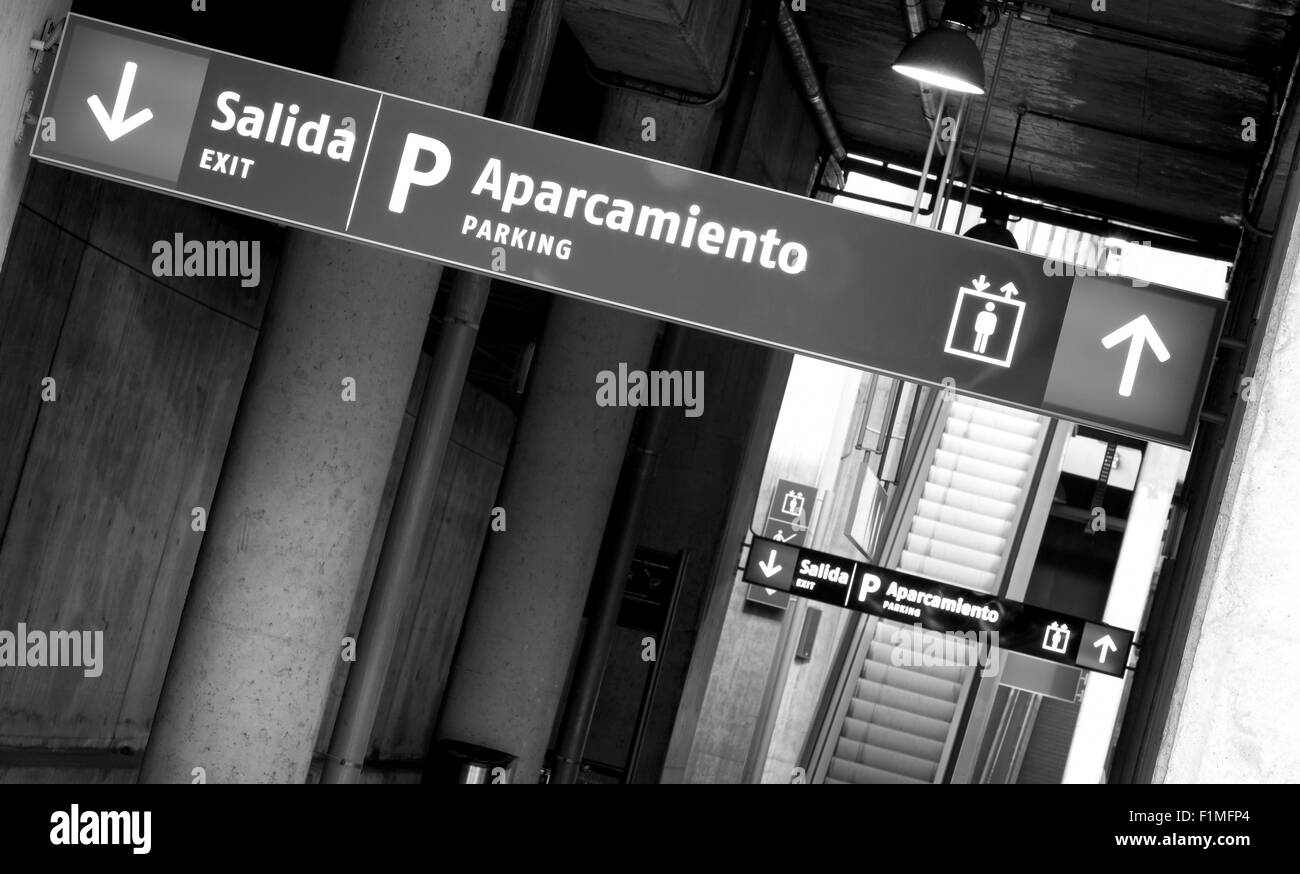 Railway station with signposting and escalators black and white Stock ...