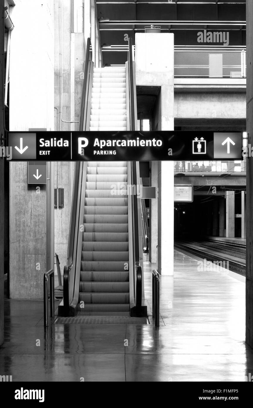 Railway station with signposting and escalators black and white Stock ...