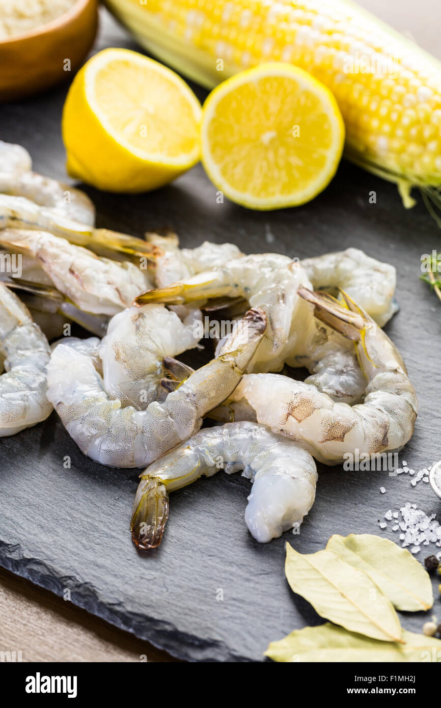 Raw peeled shrimp with tails with lemon on sutting board Stock Photo ...