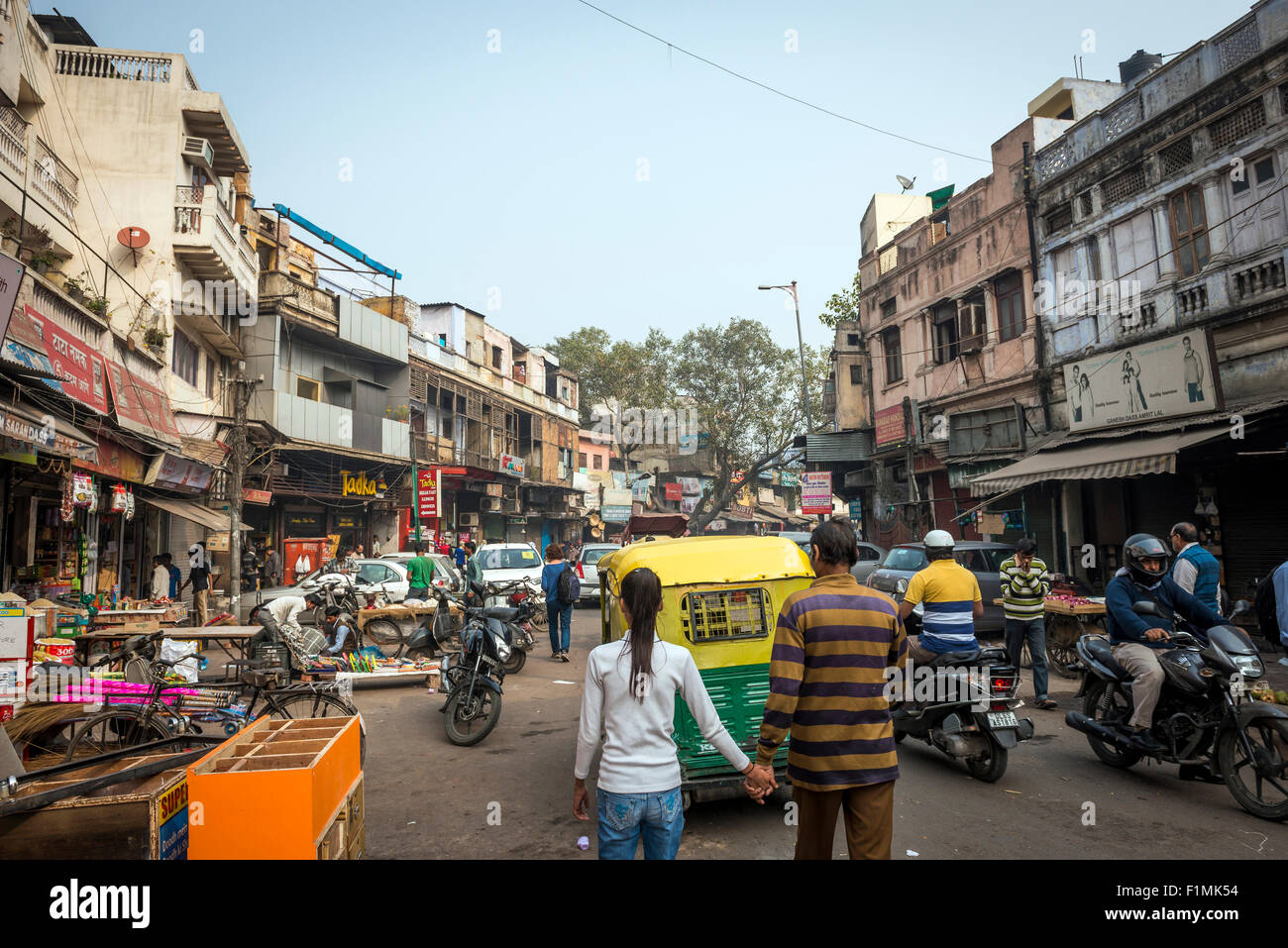 Indian couple holding hands and walking down a busy street in the ...