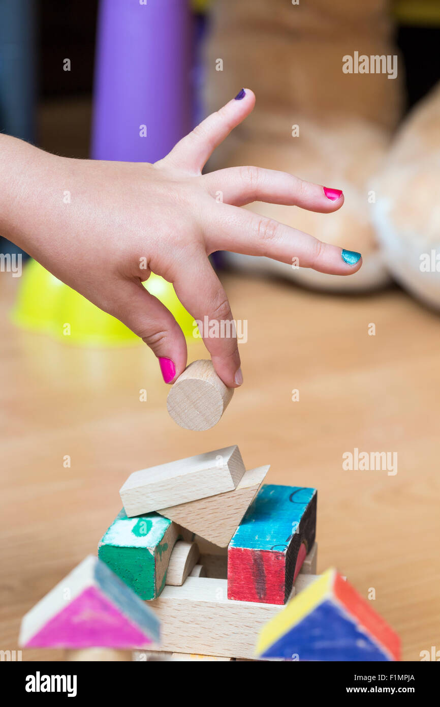 Close-up of a little girl's hand building something using wooden ...