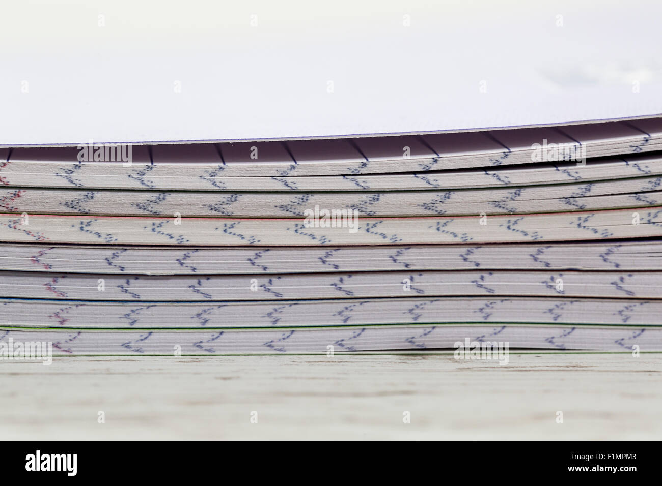 Close-up image of a stack of colorful notebooks on a white wooden table ...