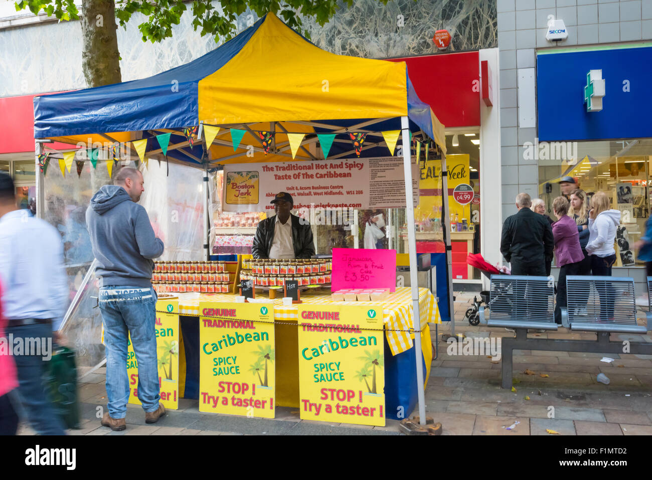 A man buying some spicy sauce from a Caribbean stall at Wolverhampton ...